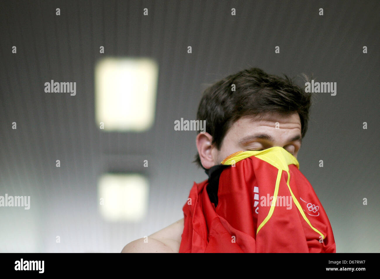 Table tennis player Timo Boll puts on a T-shirt of the Olympic uniform ...