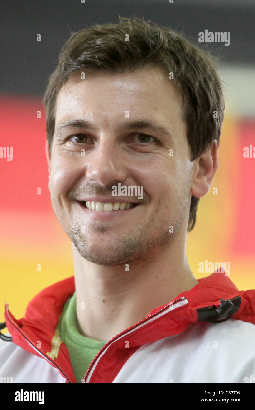 Table tennis player Timo Boll puts on a T-shirt of the Olympic uniform ...