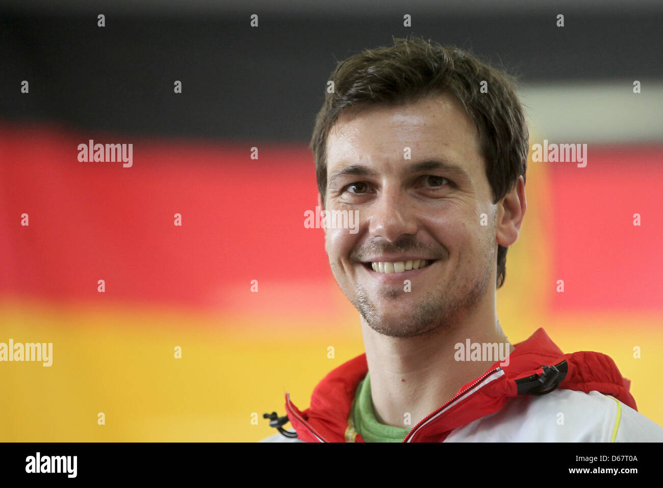 Table tennis player Timo Boll puts on a T-shirt of the Olympic uniform ...