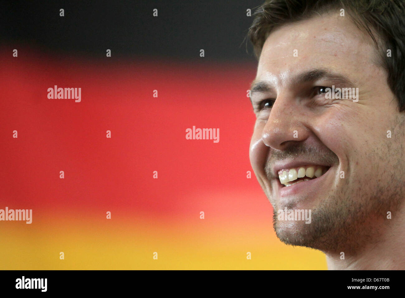 Table tennis player Timo Boll puts on a T-shirt of the Olympic uniform ...