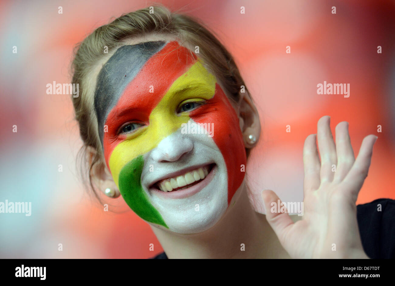 A supporter, with her face painted in German and Italian colours ...