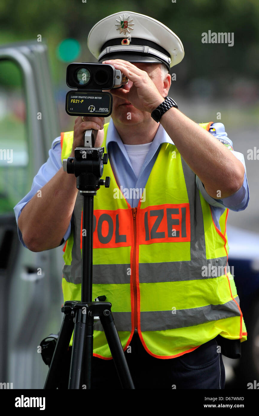 A police officer measures the speed of cars with a laser speed gun in ...