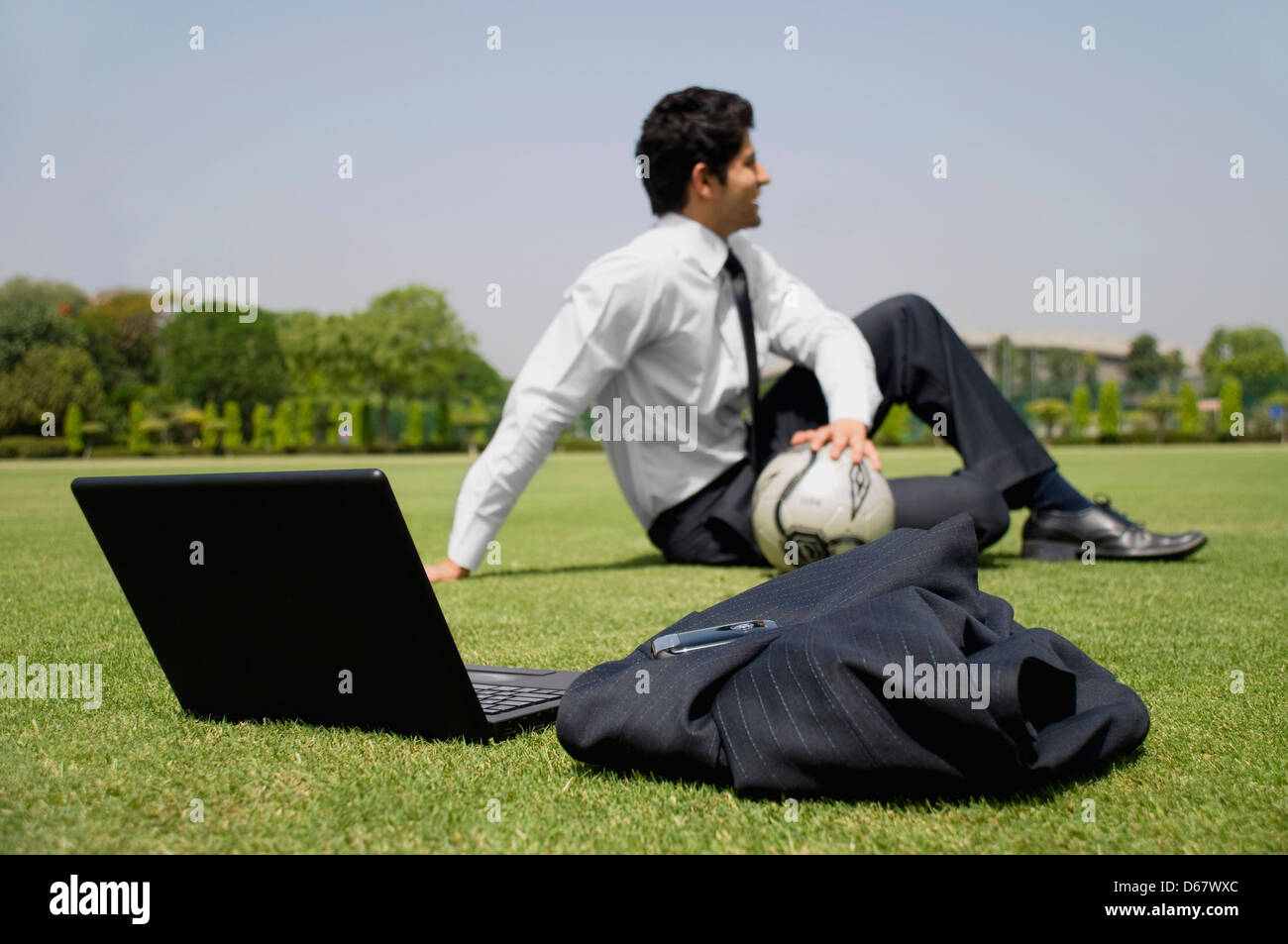 Executive sitting with a football Stock Photo - Alamy