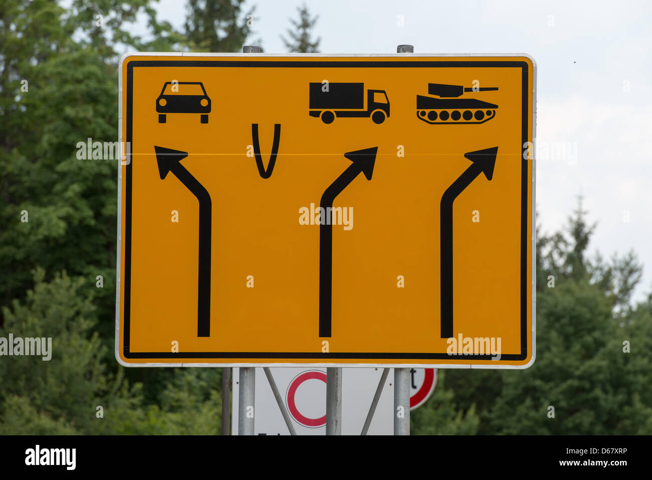A road sign for passenger cars, lorries and tanks stands on the ...