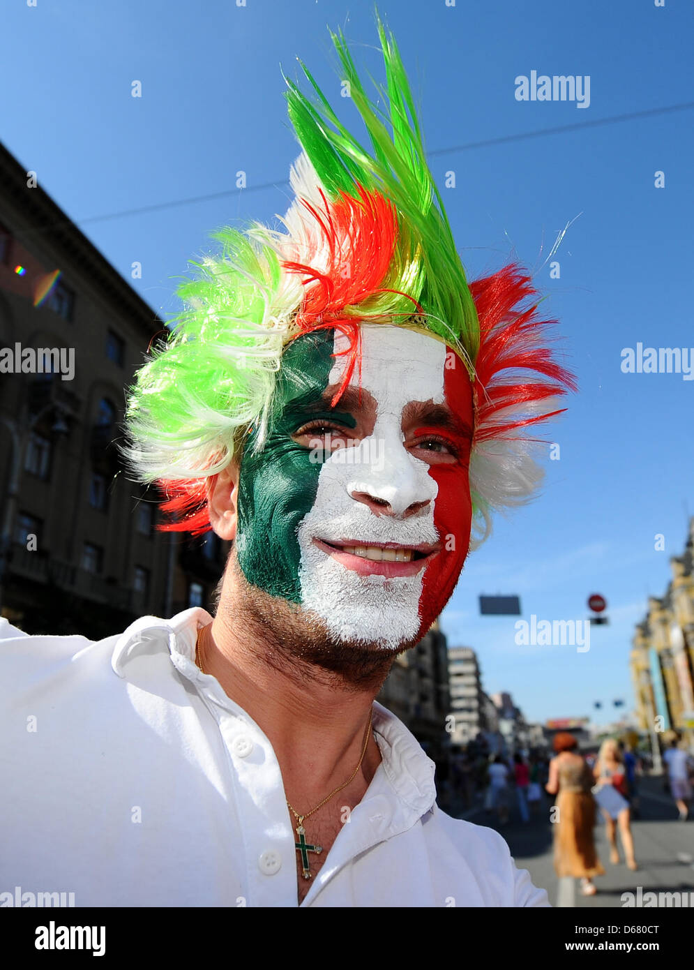 An Italian fan has his face painted in Italy's national colours in Kyiv ...