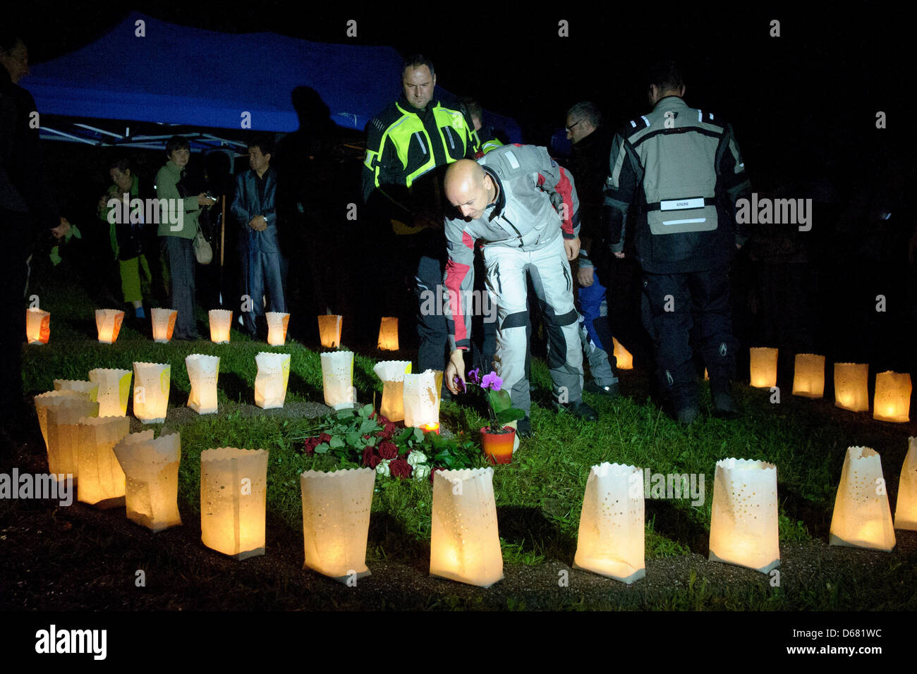 Young people put down candles at a memorial ceremony fpr the victims of ...