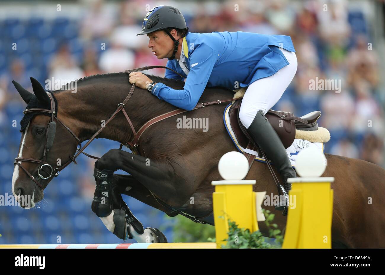 German show jumper Christian Ahlmann jumps over a hurdle on his horse ...