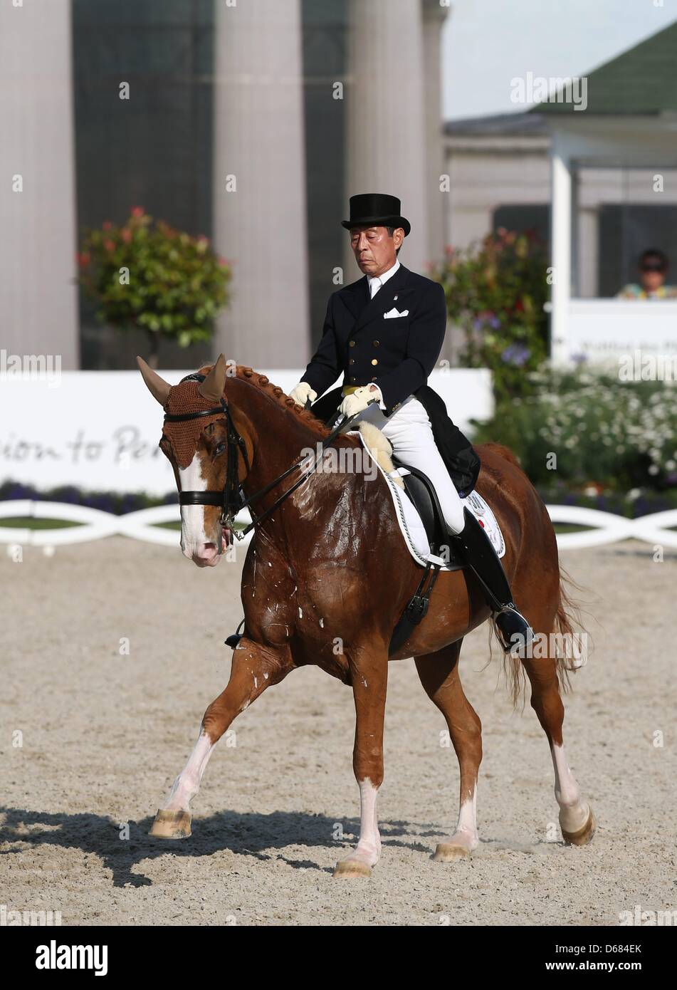 Japanese dressage rider Hiroshi Hoketsu jumps over a hurdle on his ...