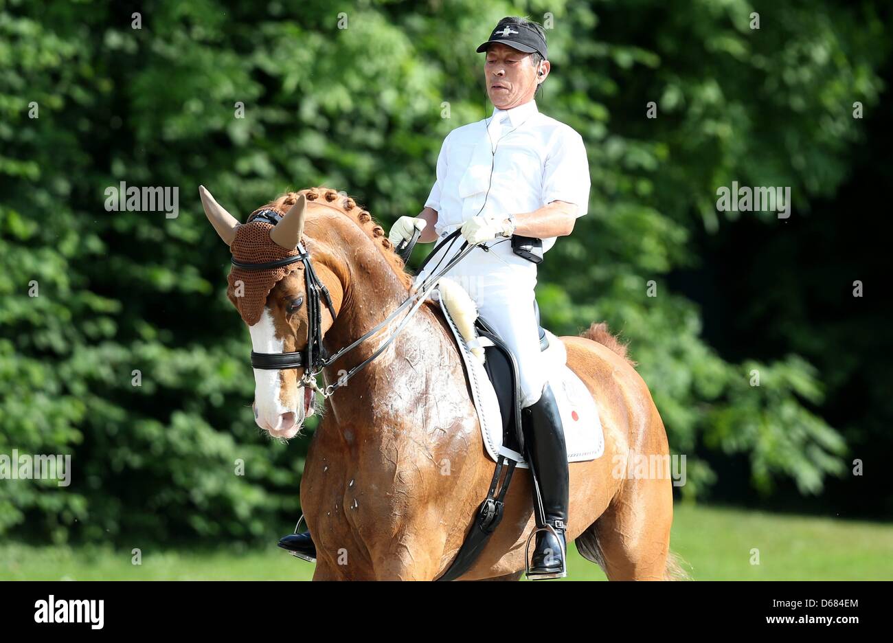 Japanese dressage rider Hiroshi Hoketsu jumps over a hurdle on his ...