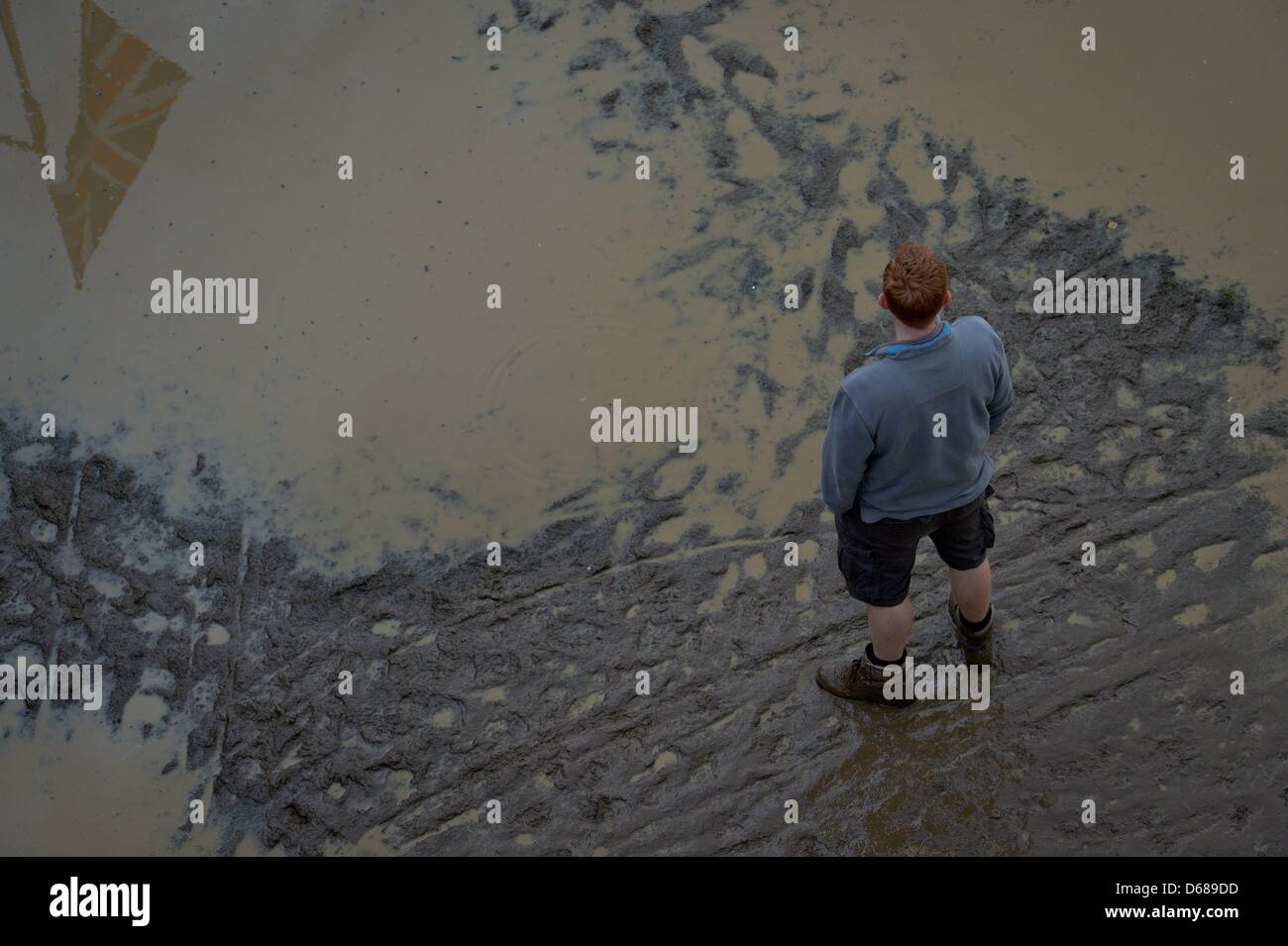 A fan stands in the mud at a campsite close to the Silverstone race ...