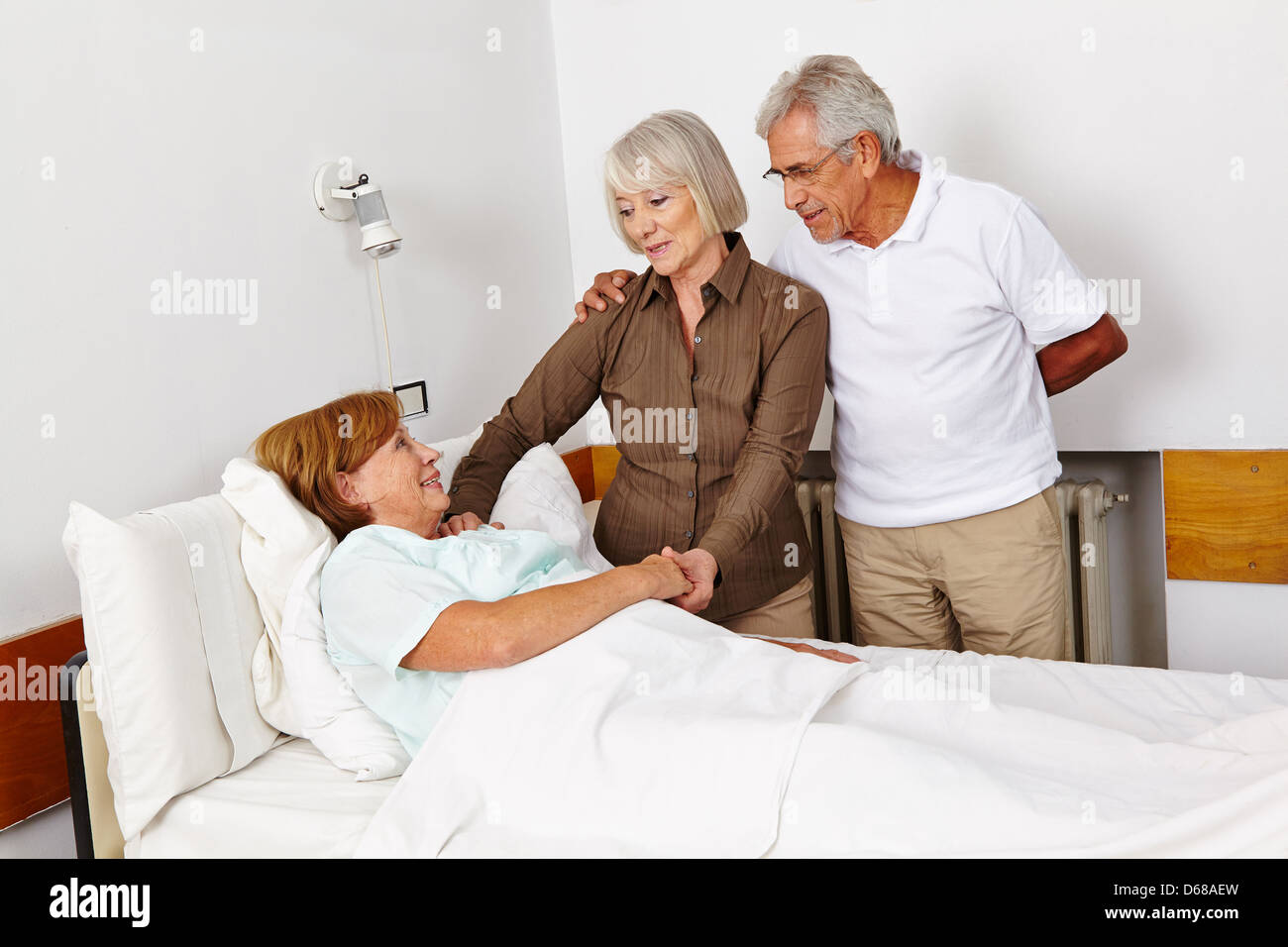Senior people visiting bedridden woman in sickbed in a hospital Stock ...
