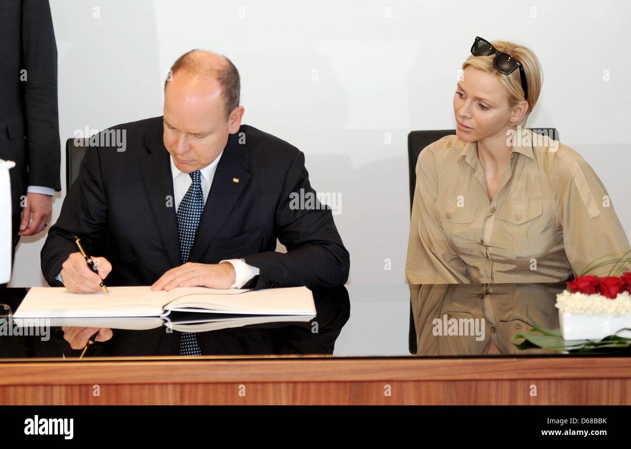 Prince Albert II of Monaco and his wife Charlene sign the guestbook at ...