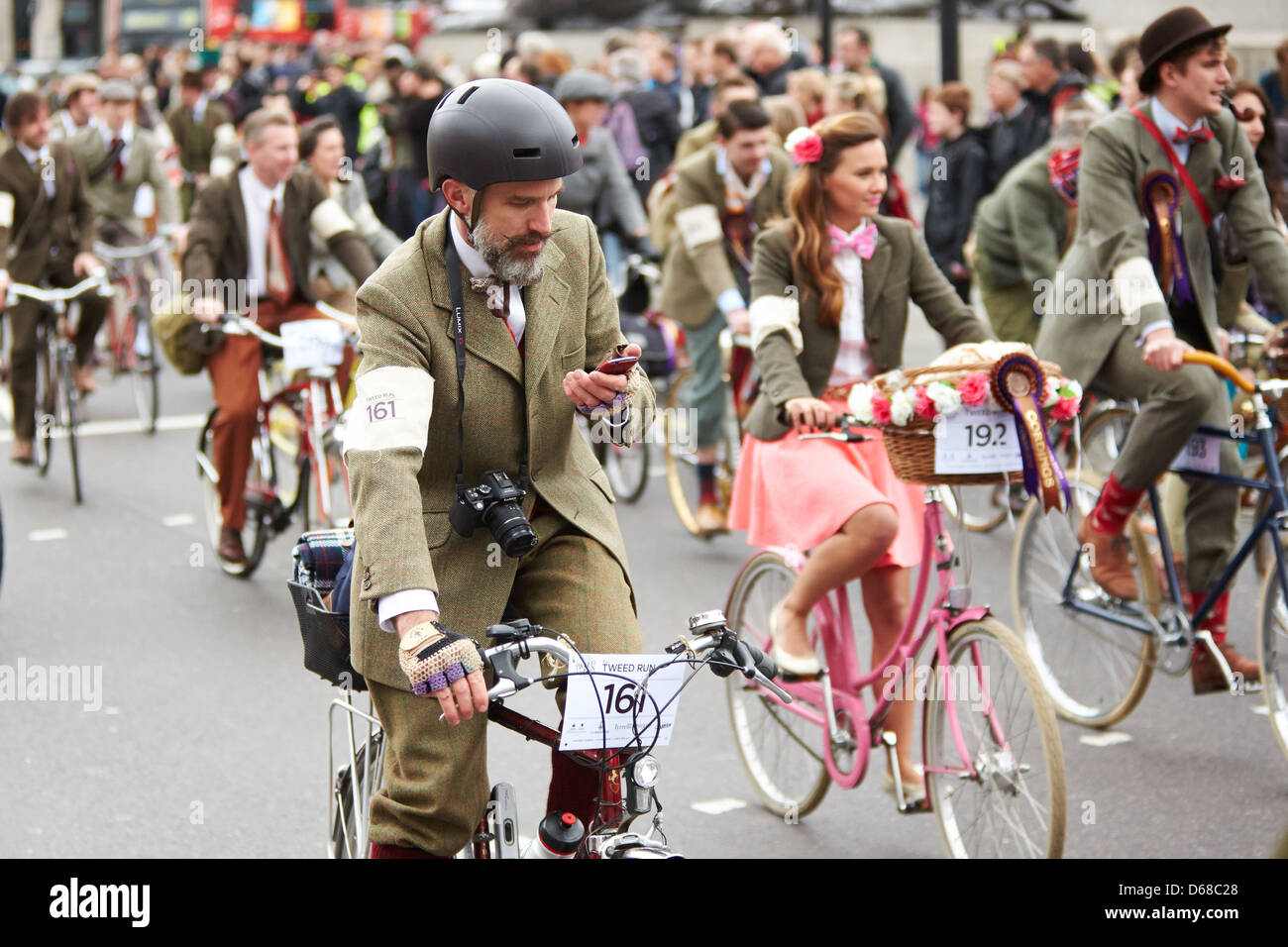 Participants in the 2013 Tweed Run bicycle ride pass thorough Trafalgar Square, London Stock ...