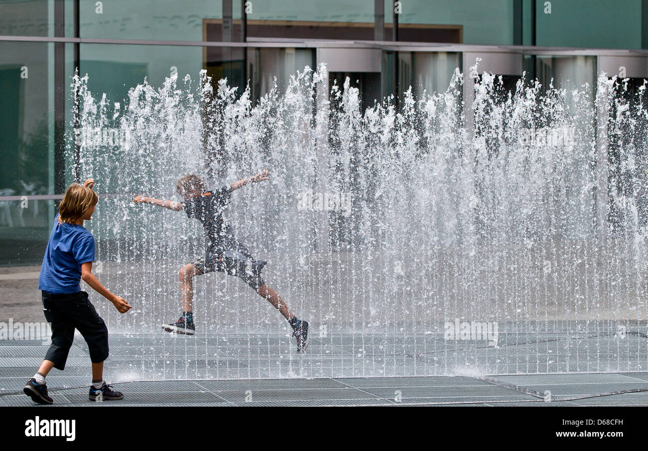 Two boys play at the water installation "Hexagonal Water Pavilion" by ...
