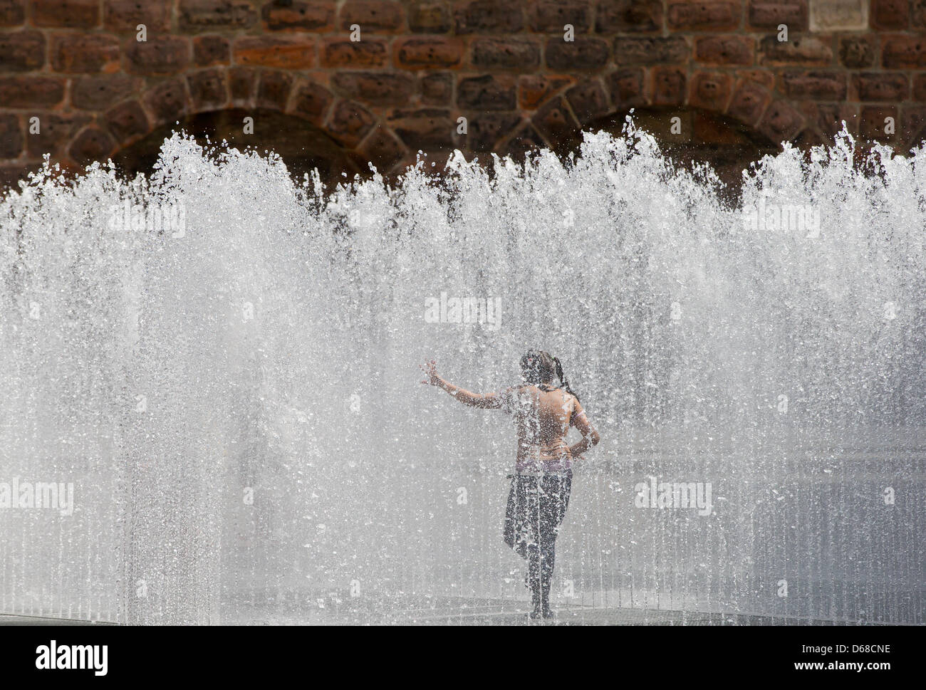 A girl plays in the water installation "Hexagonal Water Pavilion" by ...