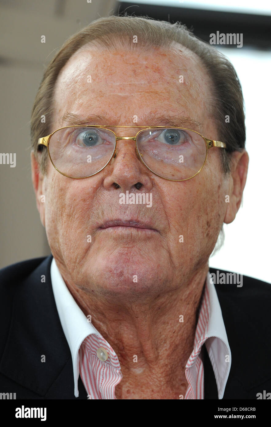 British actor Sir Roger Moore drinks visits the amusement park ...