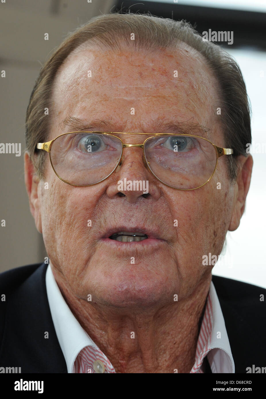 British actor Sir Roger Moore drinks visits the amusement park ...