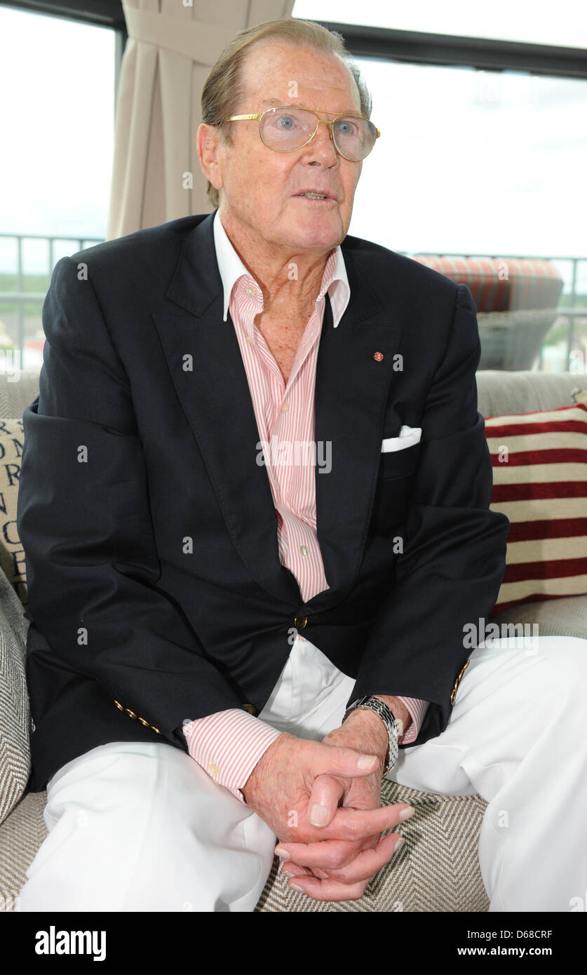 British actor Sir Roger Moore drinks visits the amusement park ...