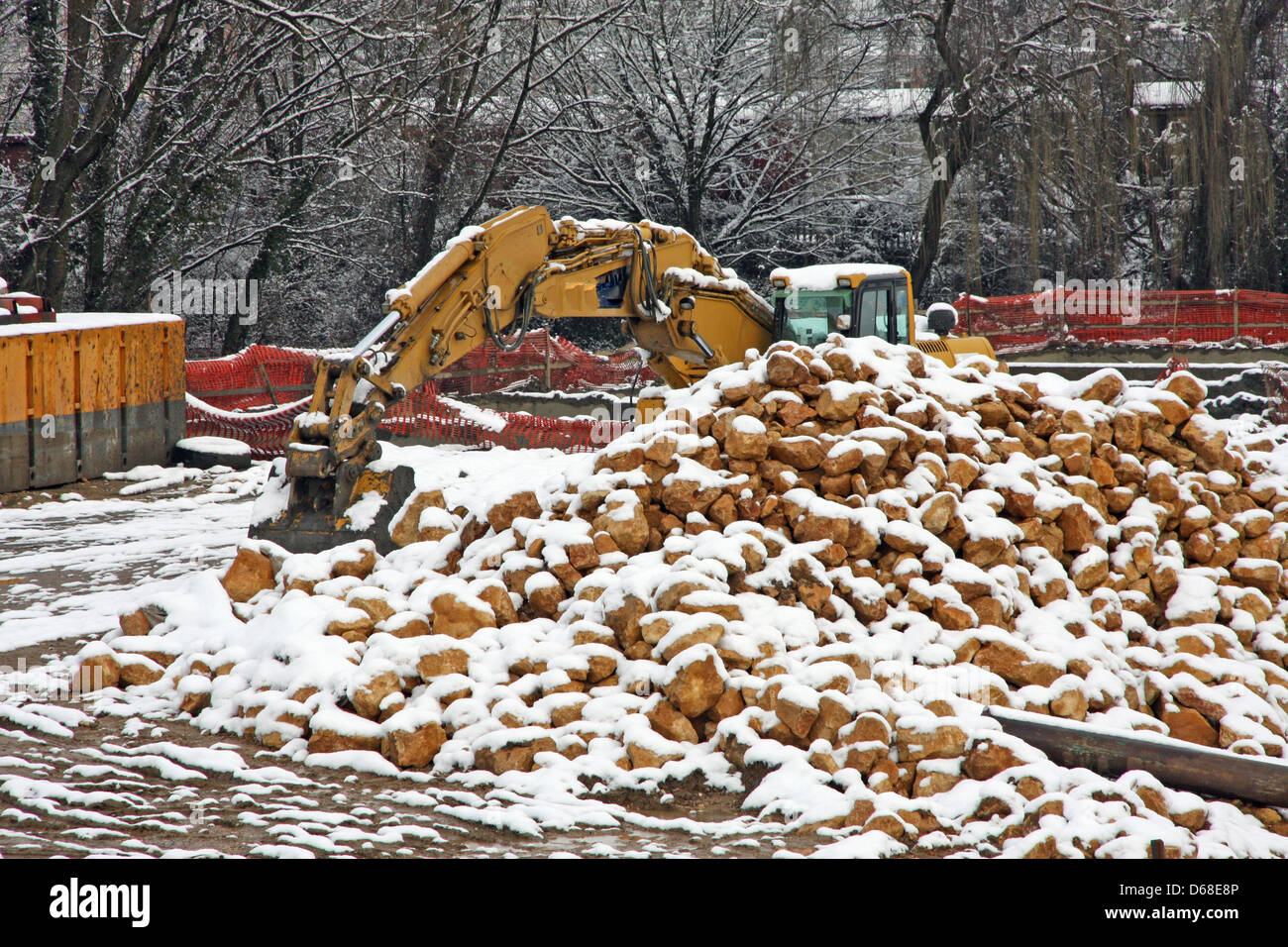 bulldozer Digger during the work with many rocks and lots of fresh snow ...