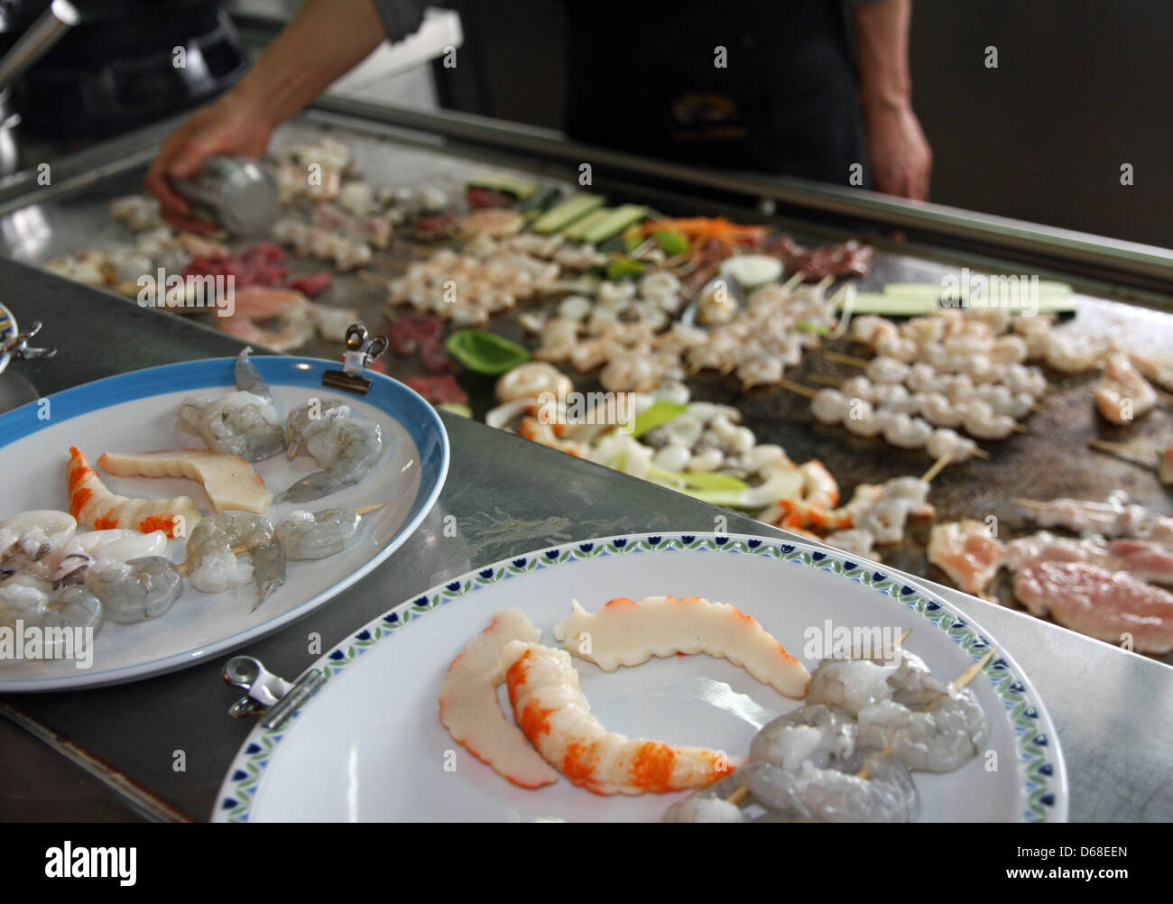 Chinese cook while it bakes vegetables fish and meat in hot grill Stock ...