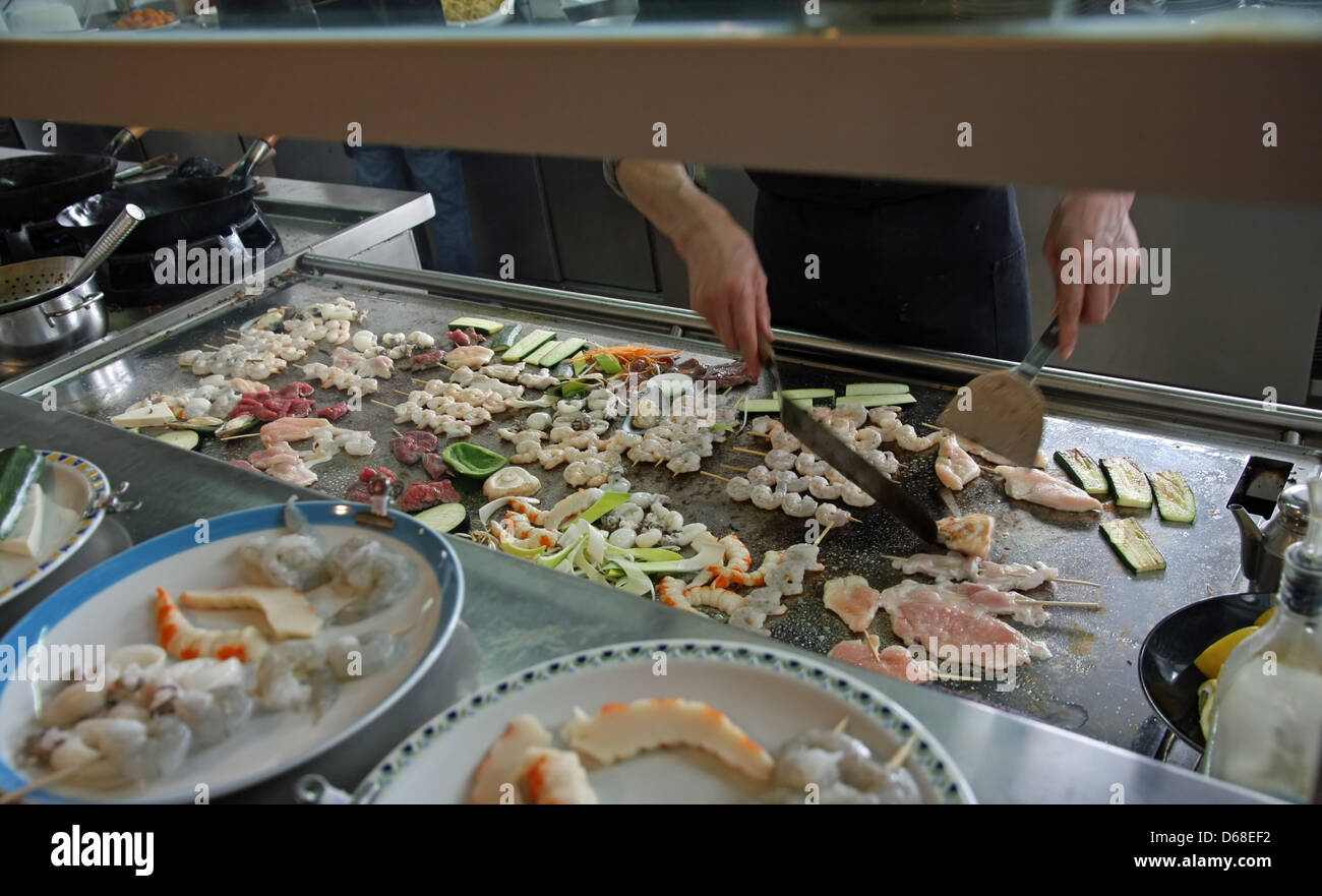 professional chef prepares dishes with vegetables and meat cooked on a ...