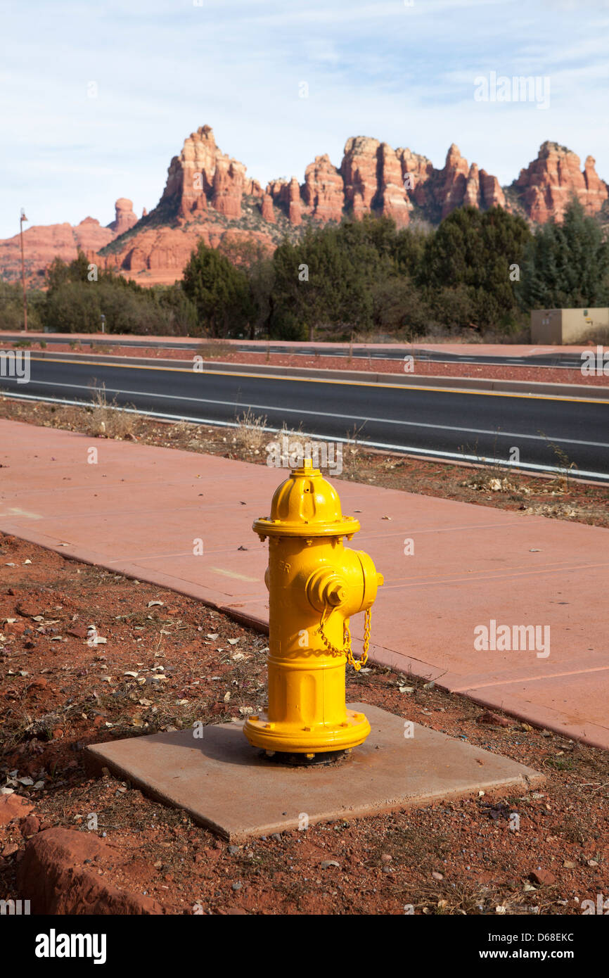 A yellow fire hydrant next to a road and red rocks in Sedona, Arizona ...