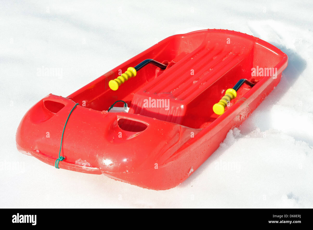red plastic bob for play and to descend from the mountains with snow ...