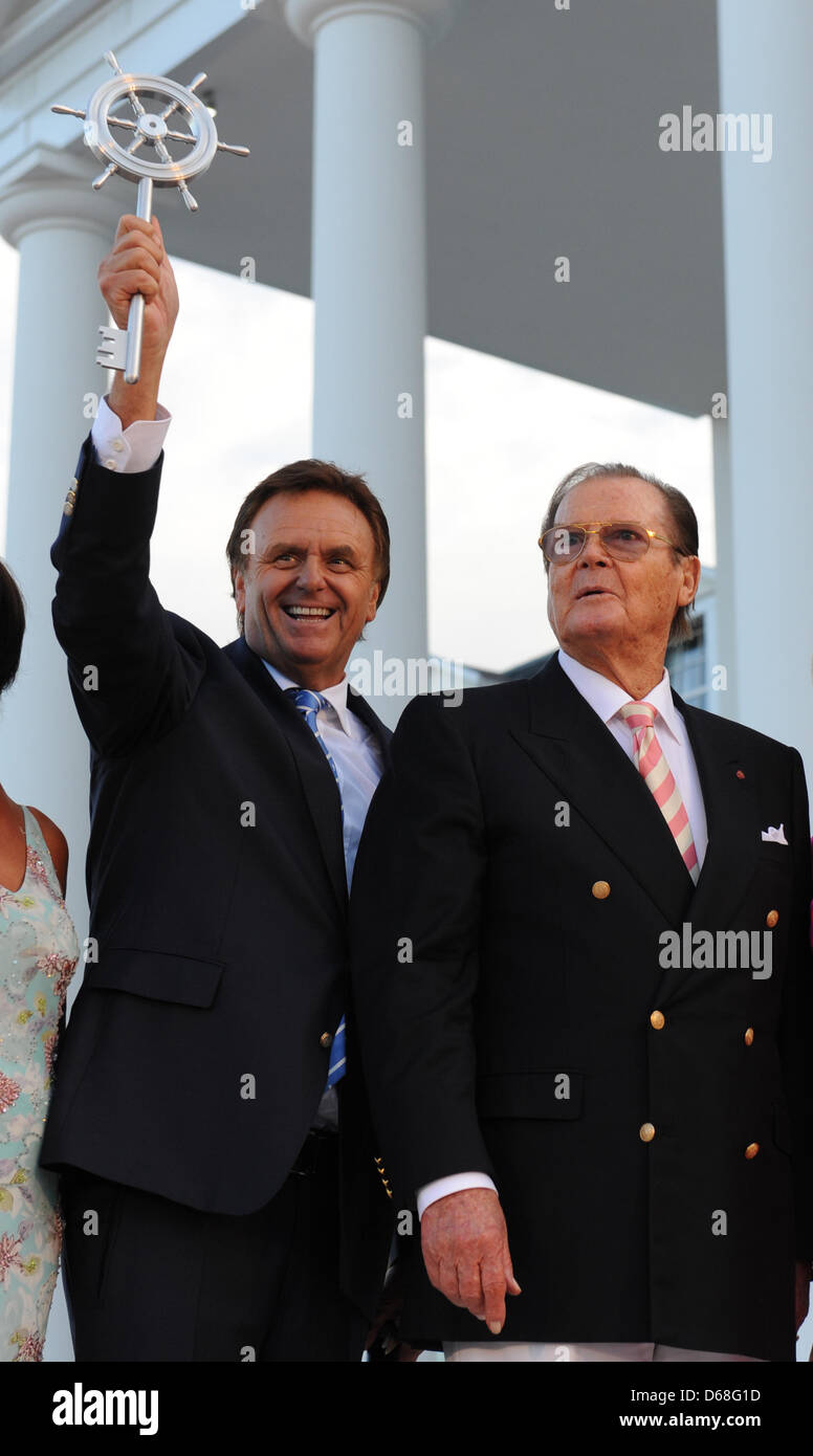 Hotel manager Roland Mack (L) and British actor Sir Roger Moore attend ...