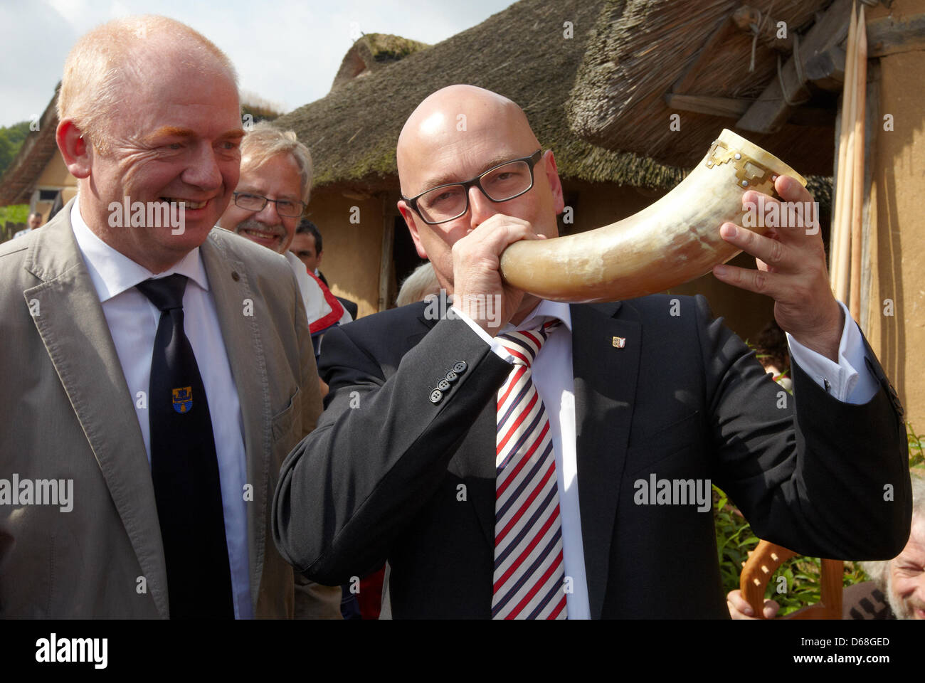 Premiere Thorsten Albig (R) blows a horn next to mayor Ralf Feddersen ...