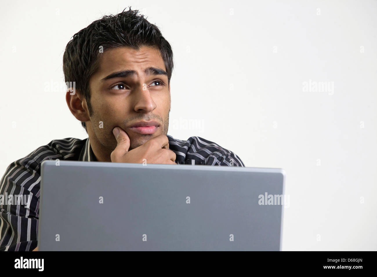 Man thinking while working on laptop Stock Photo - Alamy