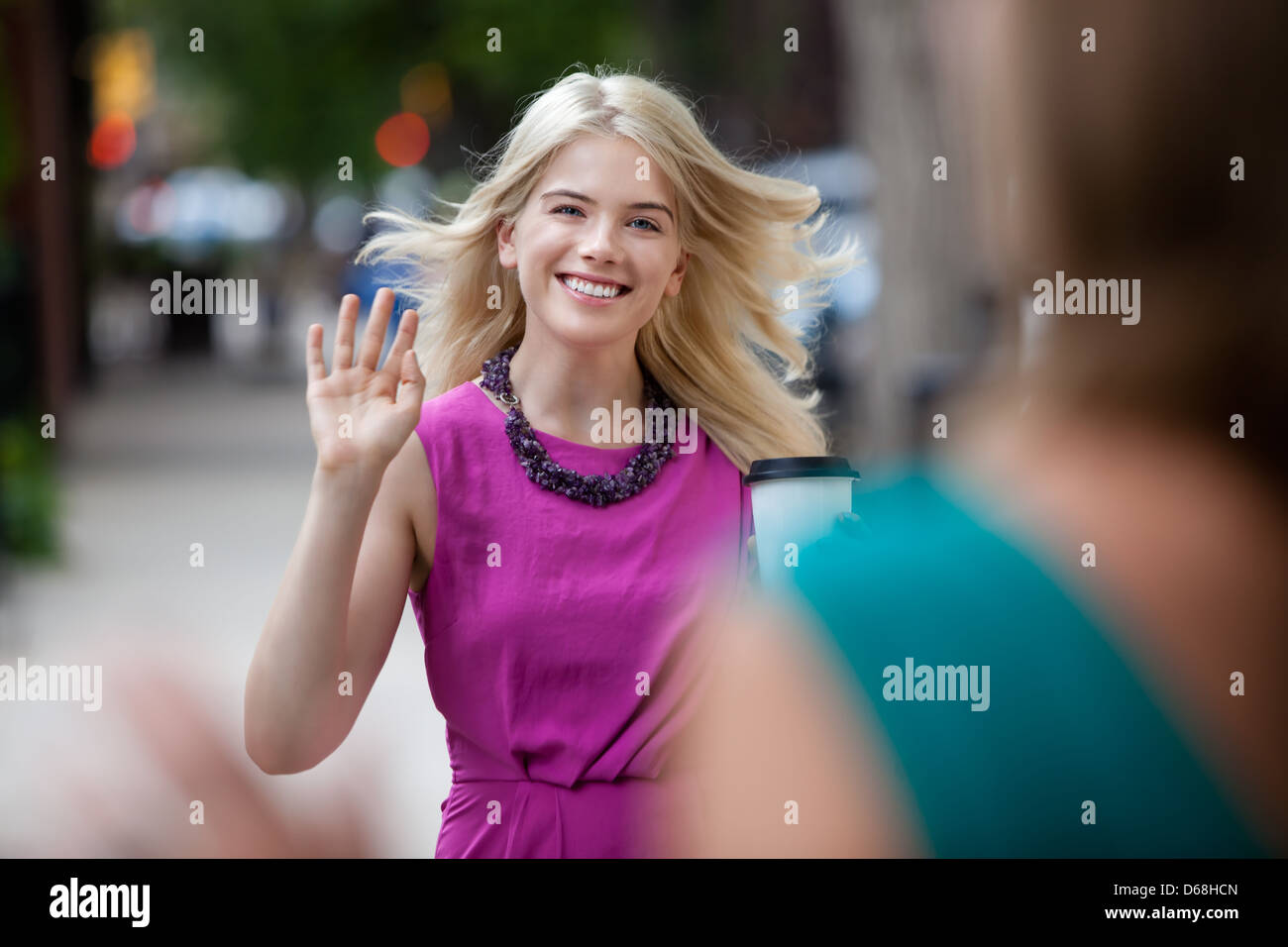 Woman Waving Hello on Street Stock Photo - Alamy