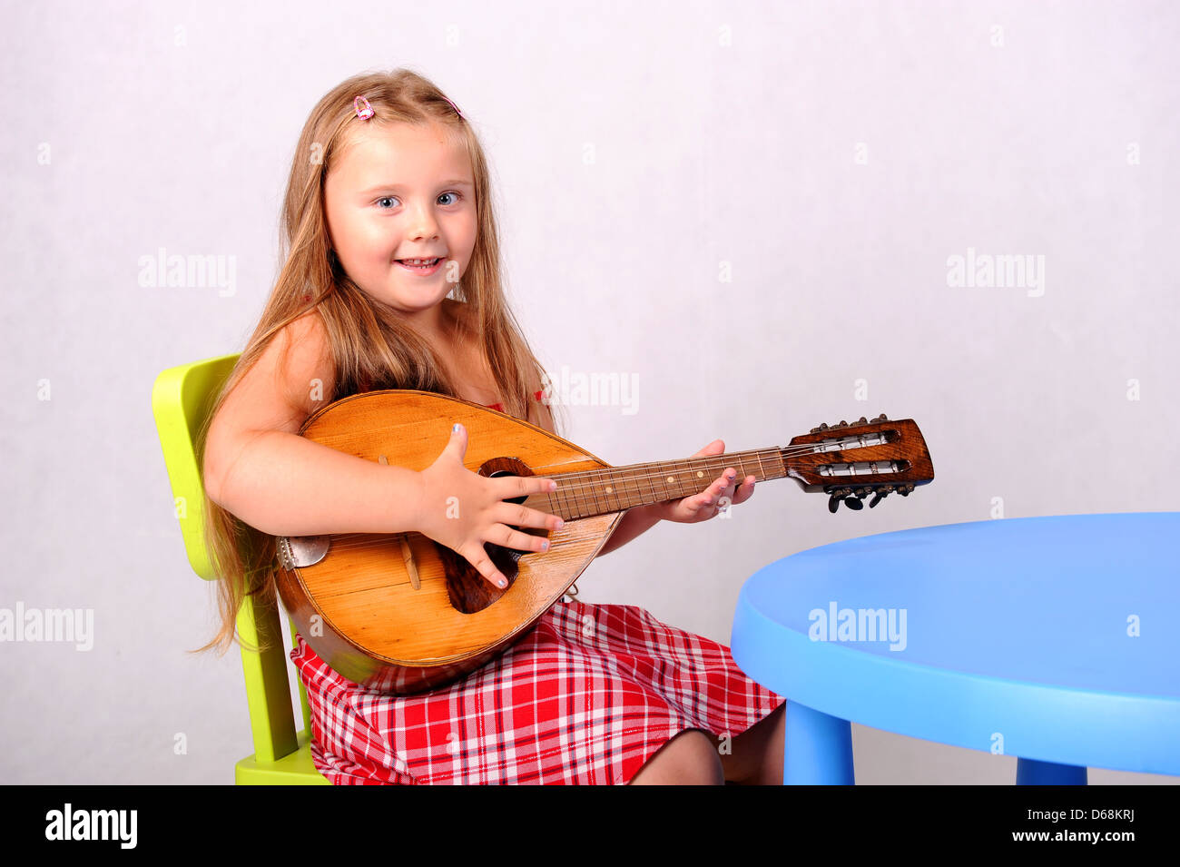 Little girl learning a string instrument Stock Photo - Alamy
