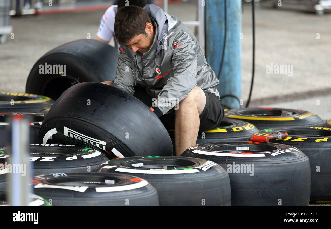 A mechanic works on racing tyres at the Hockenheimring race track in ...