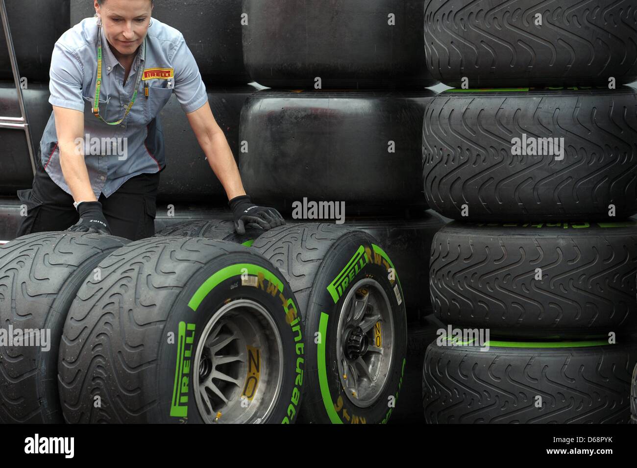 A Pirelli employee stacks wet tyres after the second practice session ...