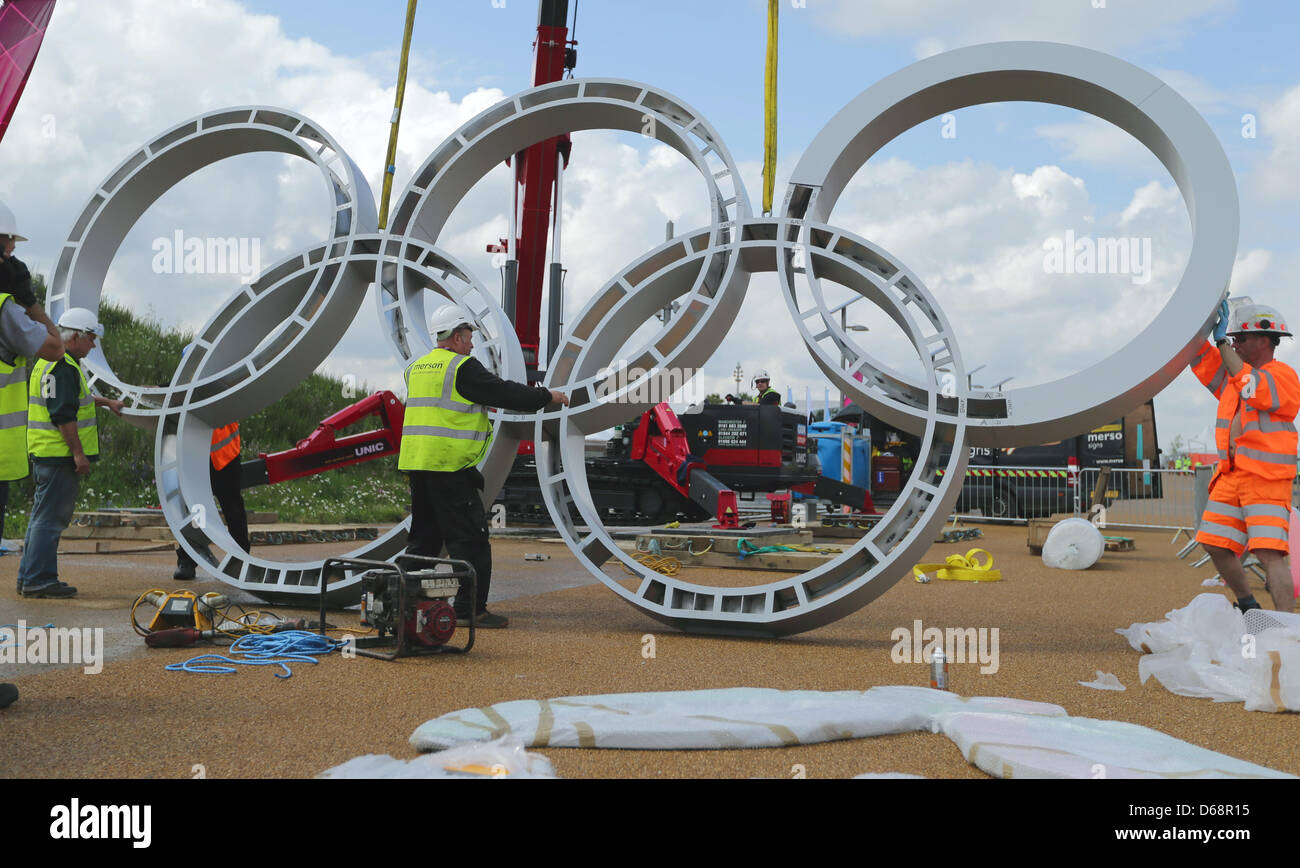 Workers prepare Olympic Rings before at the Olympic Park in London ...