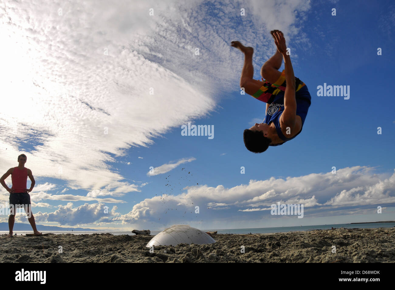 Young man somersaulting on the beach. Photographed in Nelson New ...