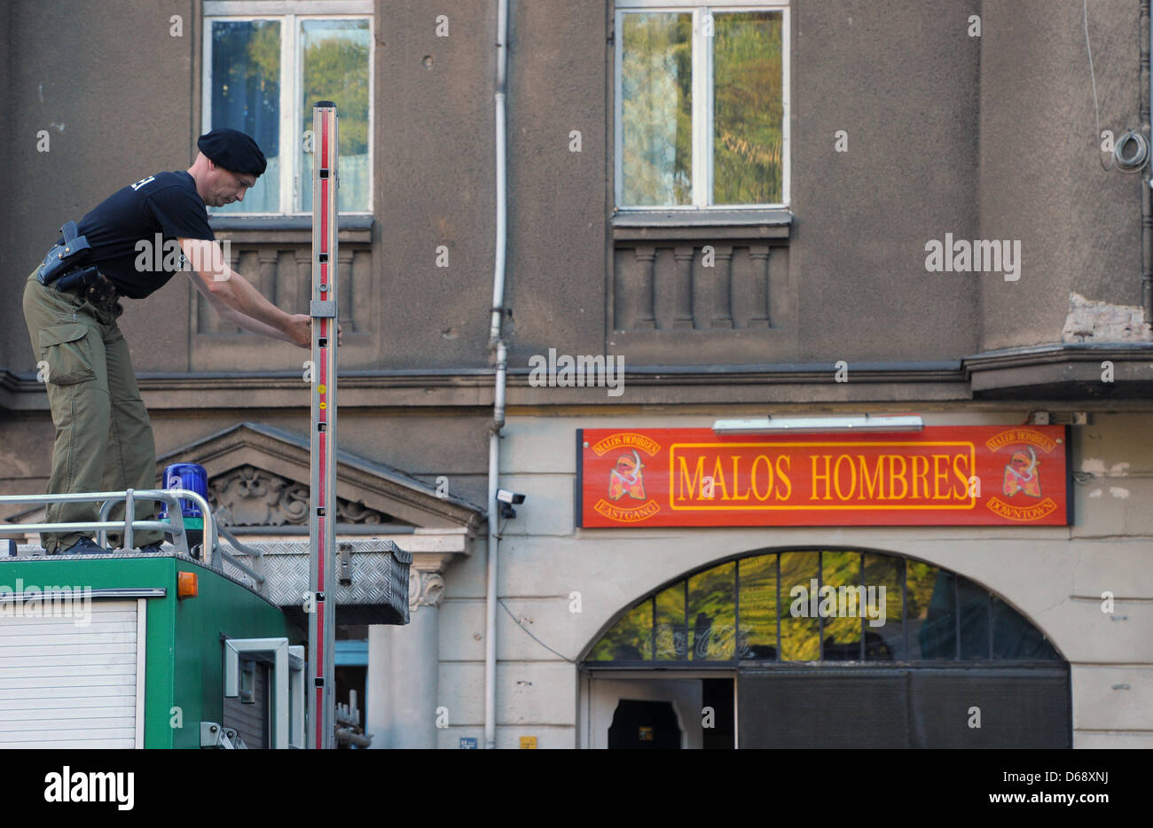A police officer lifts a ladder off of a police truck in front of an ...