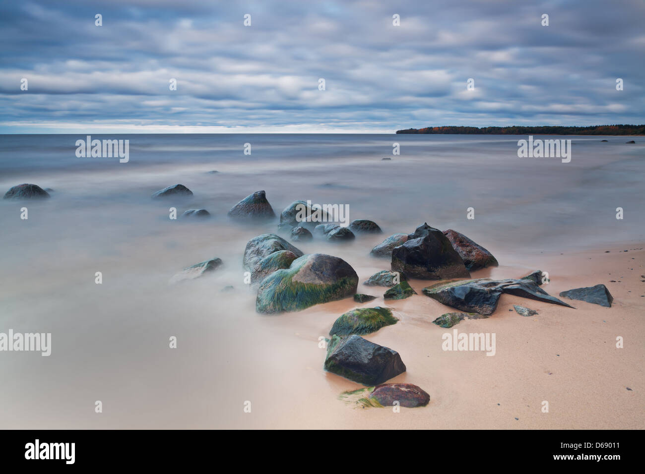 Wet stones in the lake surf on the sand beach. Long exposure Stock ...
