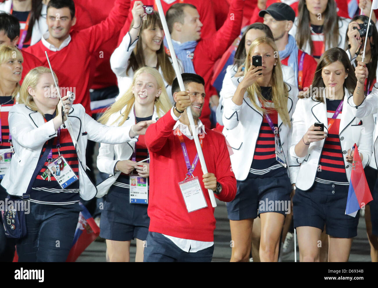 Serbia's flag bearer Novak Djokovic (C) leads the team into the stadium ...