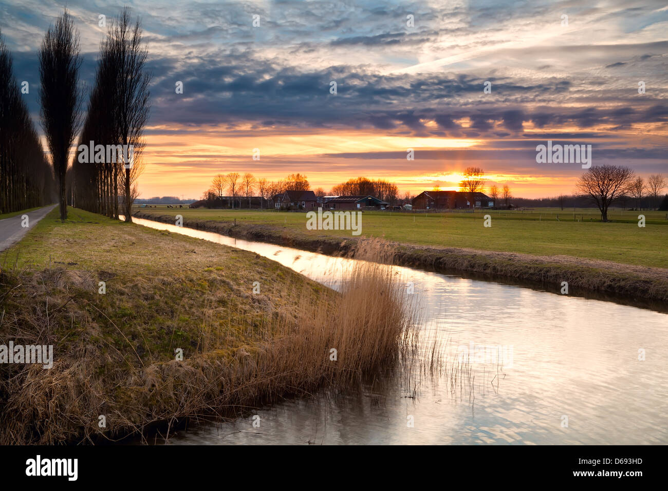 dramatic sunset over river and farmhouses on Dutch farmland Stock Photo ...