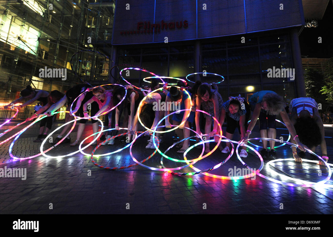 Women dance with hula hoops during a flash mob as part of the hula hoop ...