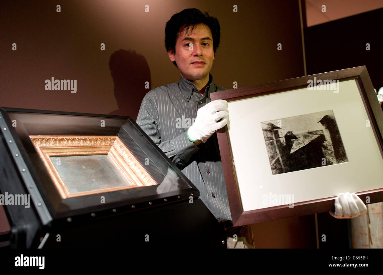 Curator Claude Wang Sui stands next to the world's oldest photograph (L ...