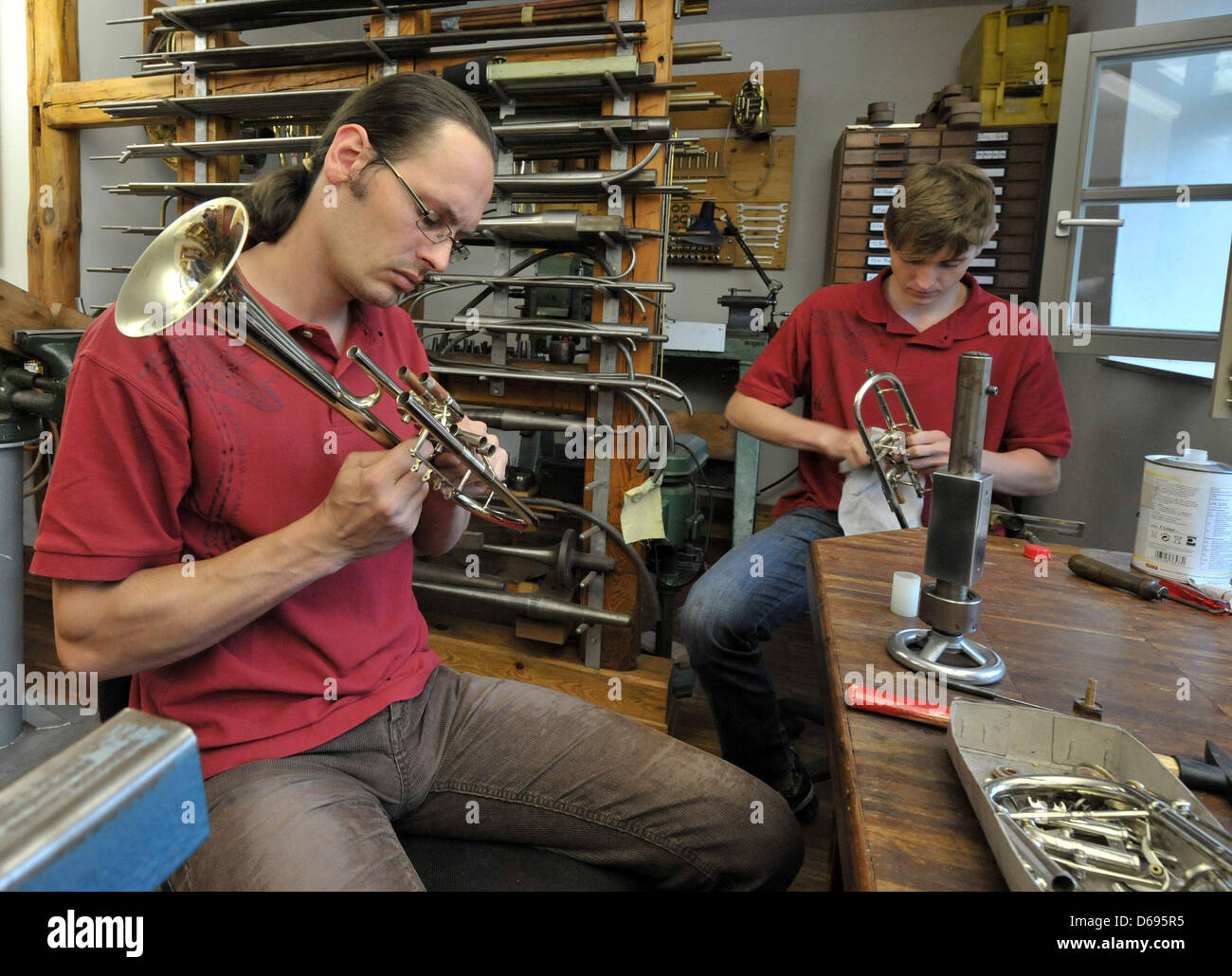Instrument makers Rene Kurth (L) and apprentice Philip Josiger work on ...