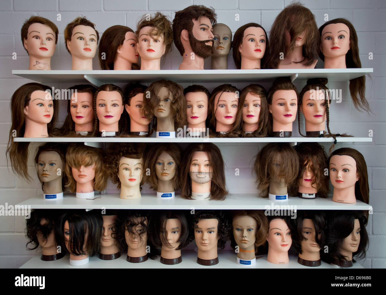 Practice heads for hairdressing apprentices stand in a shelf at the SOS ...