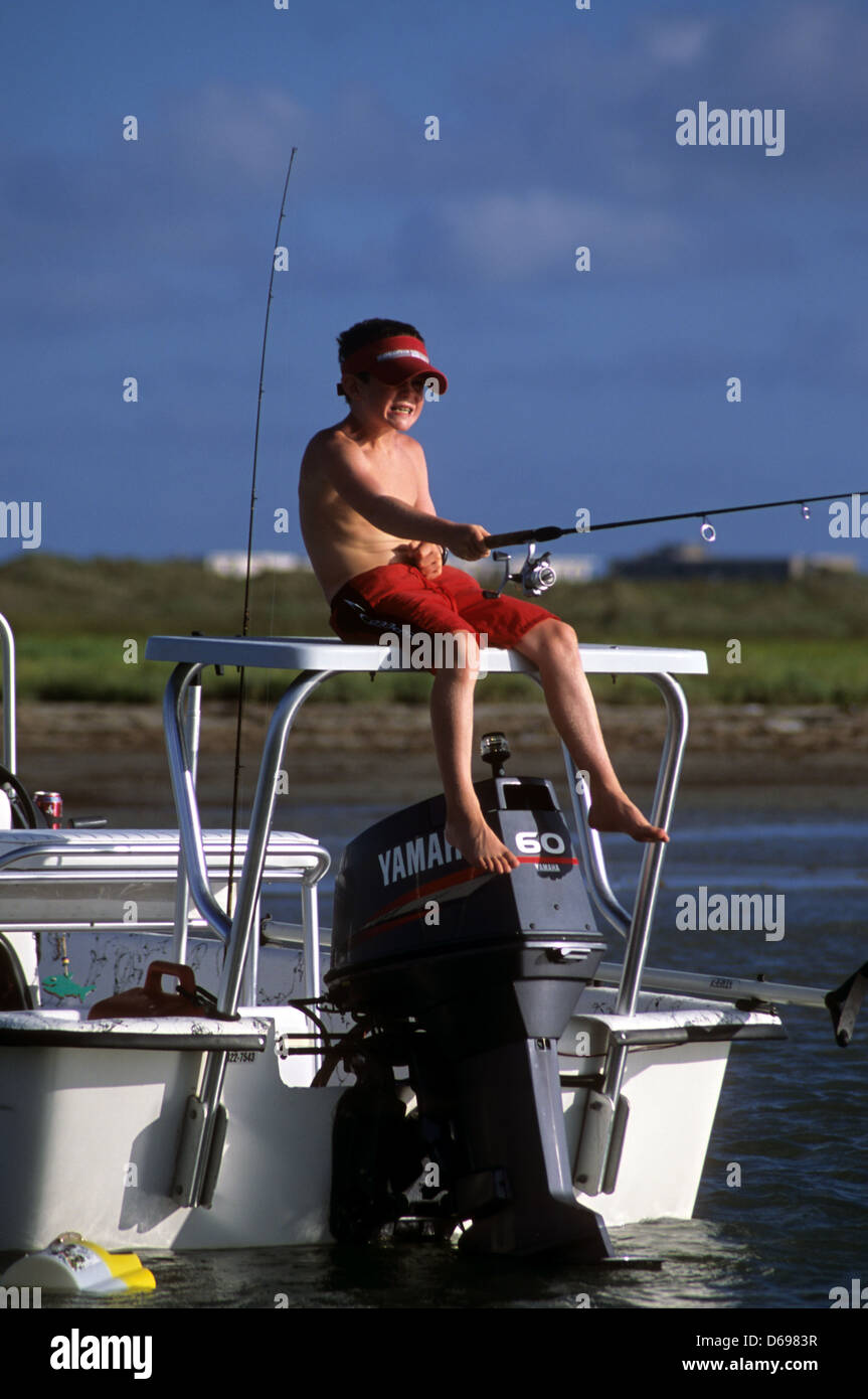 Young boy fishing for speckled trout and redfish from a boat near Port ...