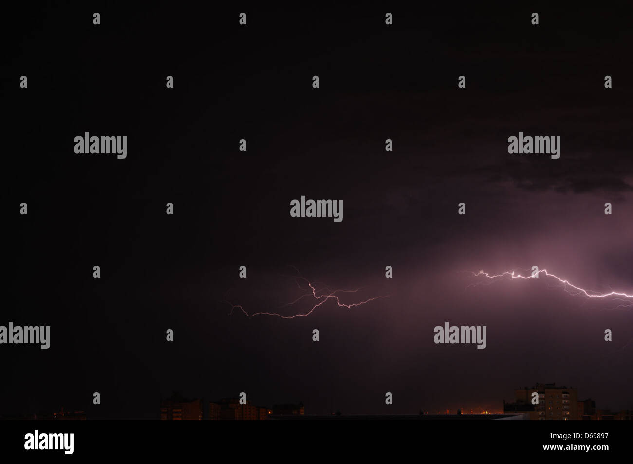 A powerful lightning strike lights up the night sky, captured in a ...