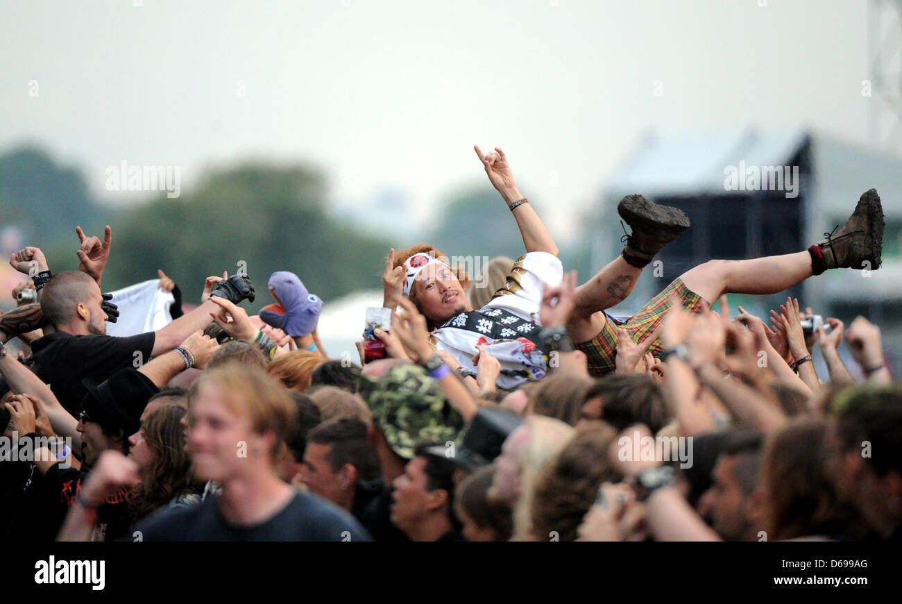 A man crowd surfes during a concert of the band Saxon at Wacken Open ...