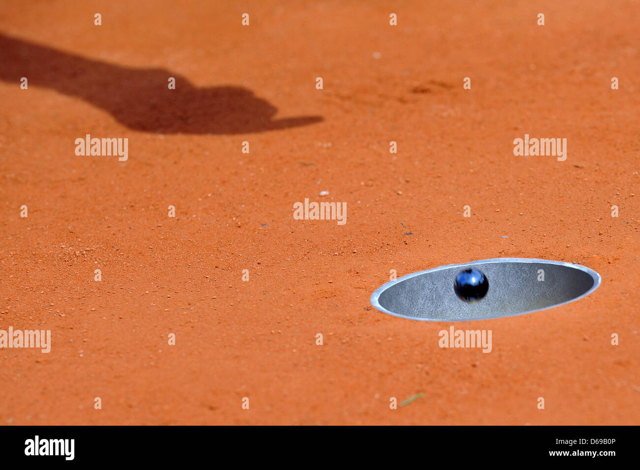 A black marble falls into the hole at the German Marbles Championship ...