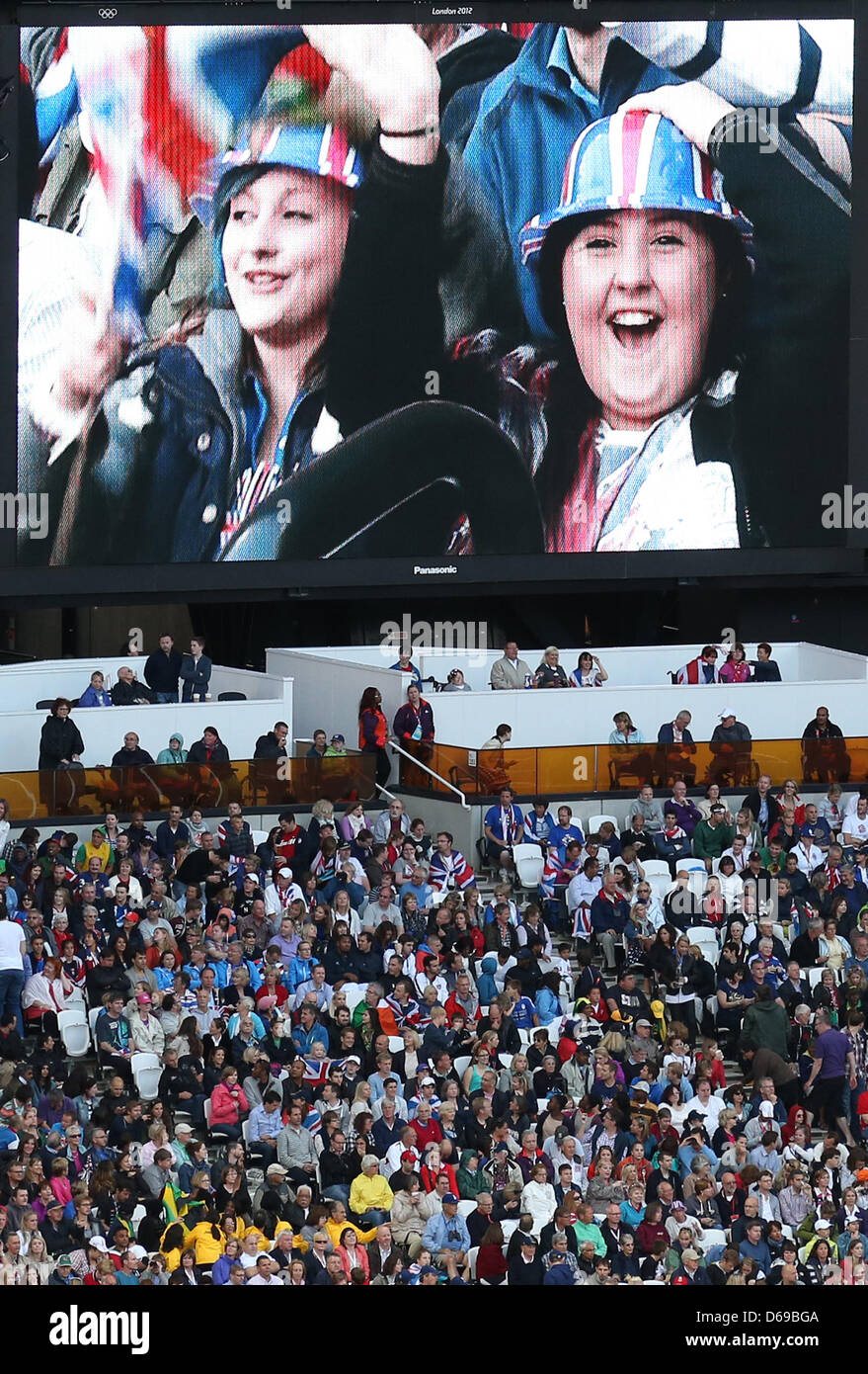Spectators cheer on a big screen of the Olympic Stadium during the ...