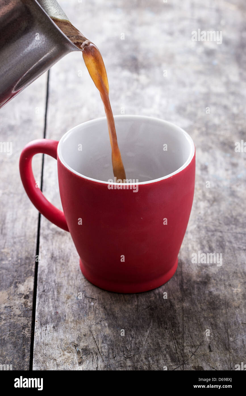 Pouring a Fresh Cup of Brewed Coffee against wooden Background. Studio ...